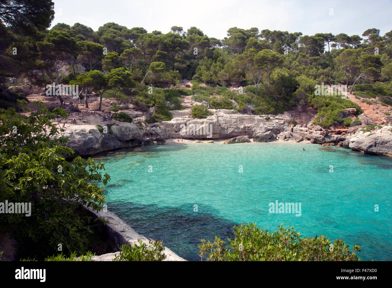 The clear azure waters of cala Mitjana from the cliffs above on the ...