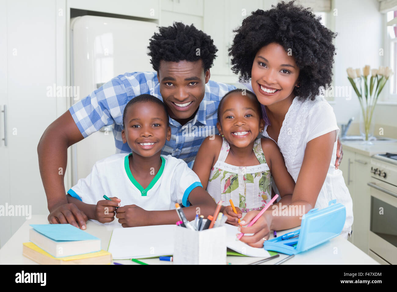 Happy parents helping children with homework Stock Photo - Alamy