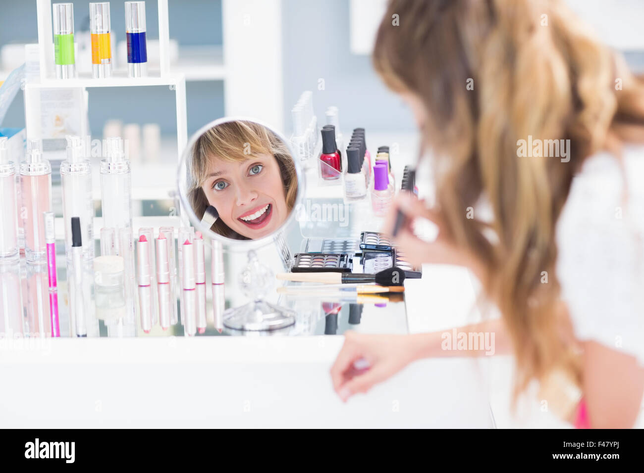 Beautiful costumer looking through mirror at camera Stock Photo - Alamy