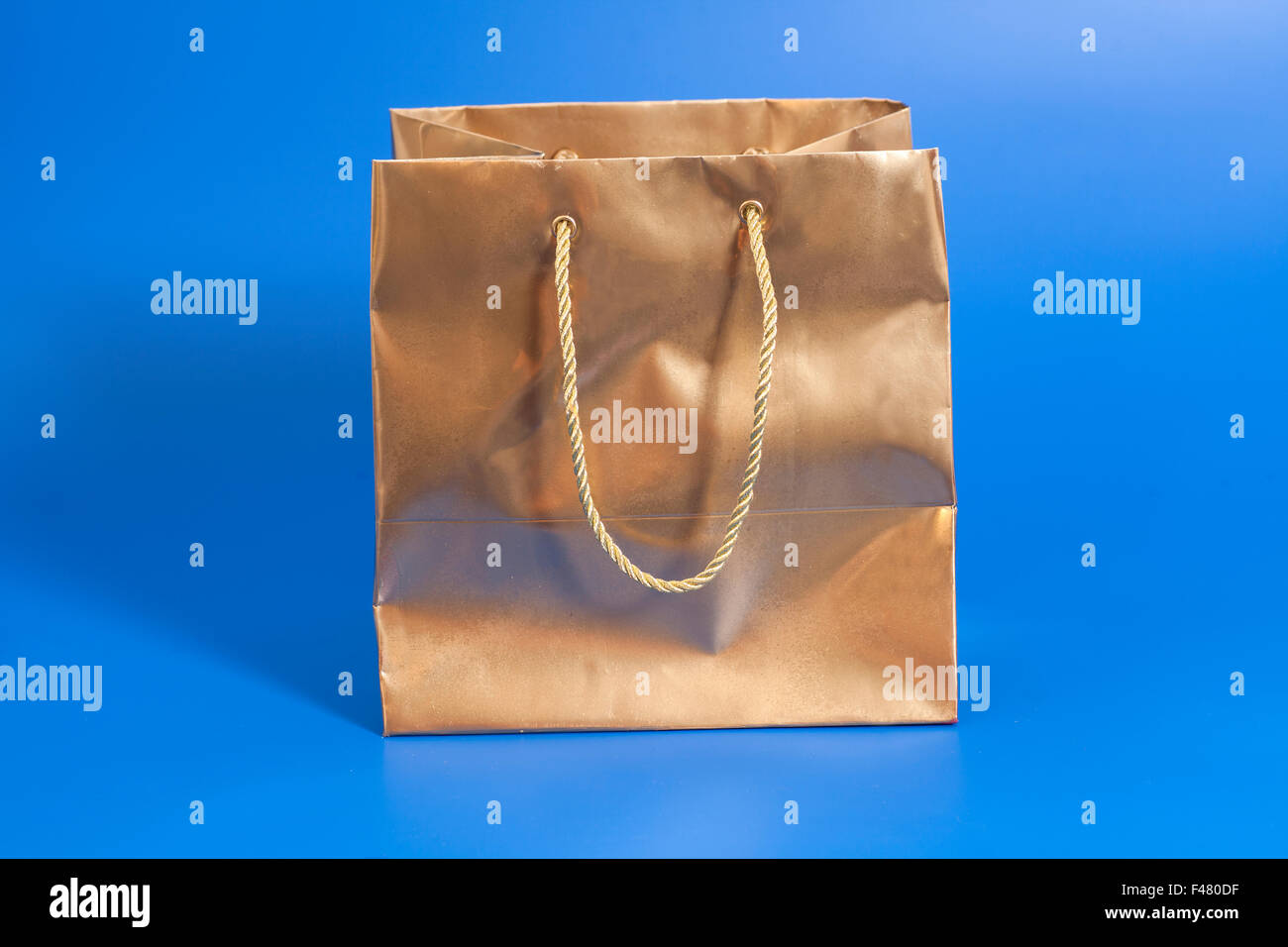 Golden package for gift on blue background Stock Photo - Alamy