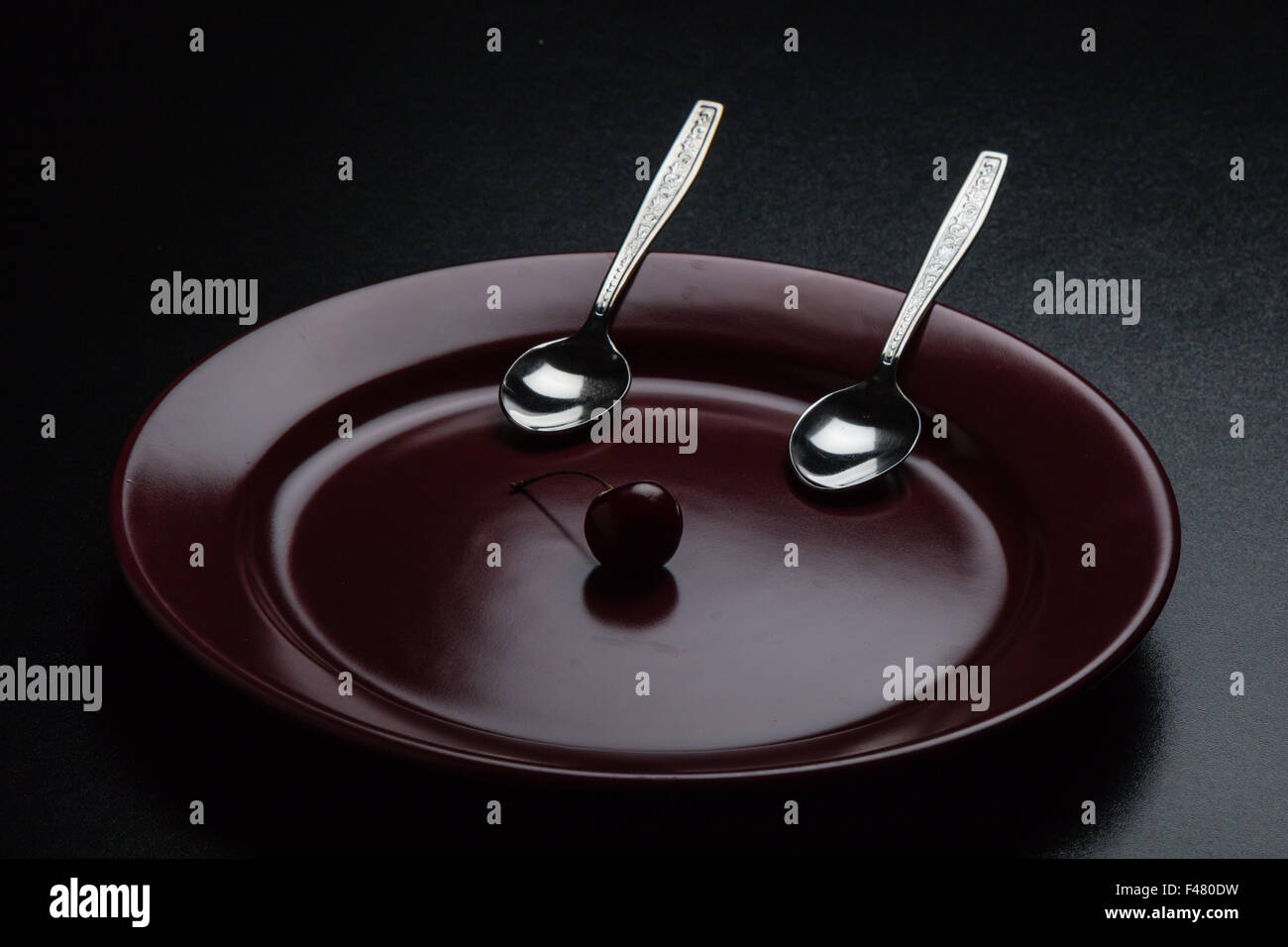 two spoons and a cherry Stock Photo - Alamy