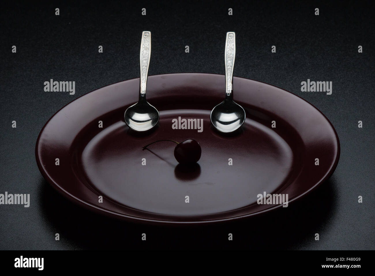 two spoons and a cherry Stock Photo - Alamy