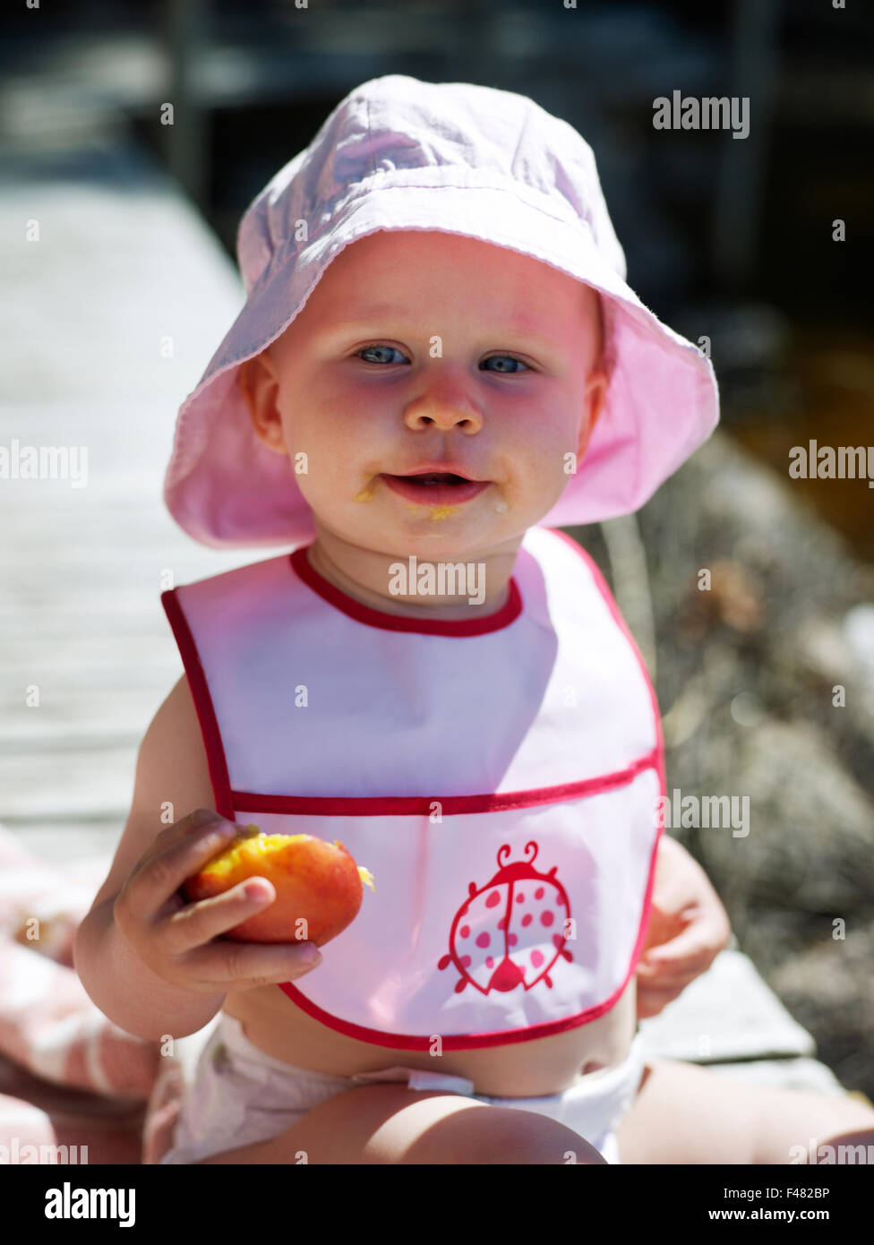 Small girl eating a peach, Sweden Stock Photo - Alamy