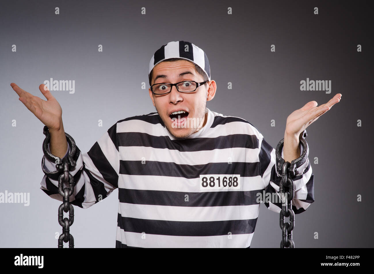 Funny prisoner in chains isolated on gray Stock Photo - Alamy