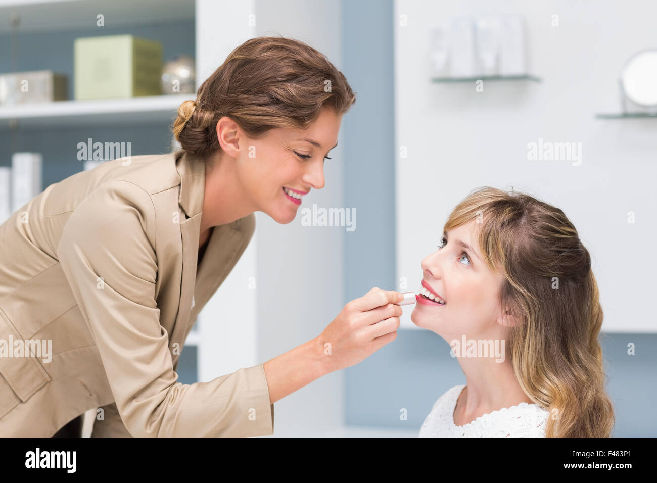 Beautiful employee doing makeup for a costumer Stock Photo - Alamy