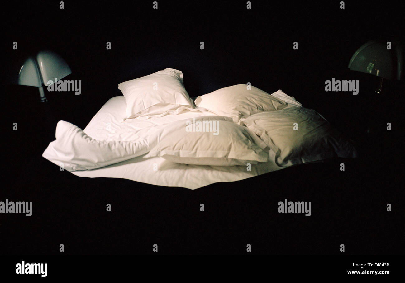 An unmade bed in a black room, France Stock Photo - Alamy