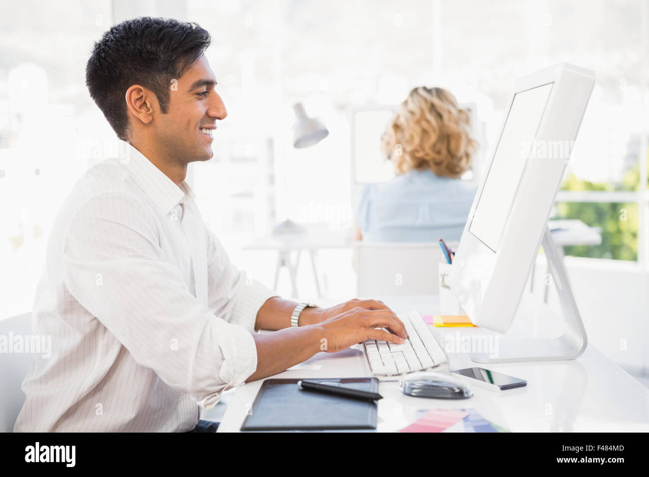 Young smiling business people typing on the computer Stock Photo - Alamy