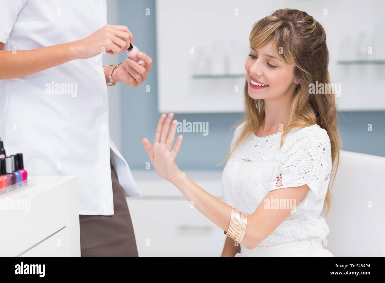 Beautiful costumer examining her nails Stock Photo - Alamy