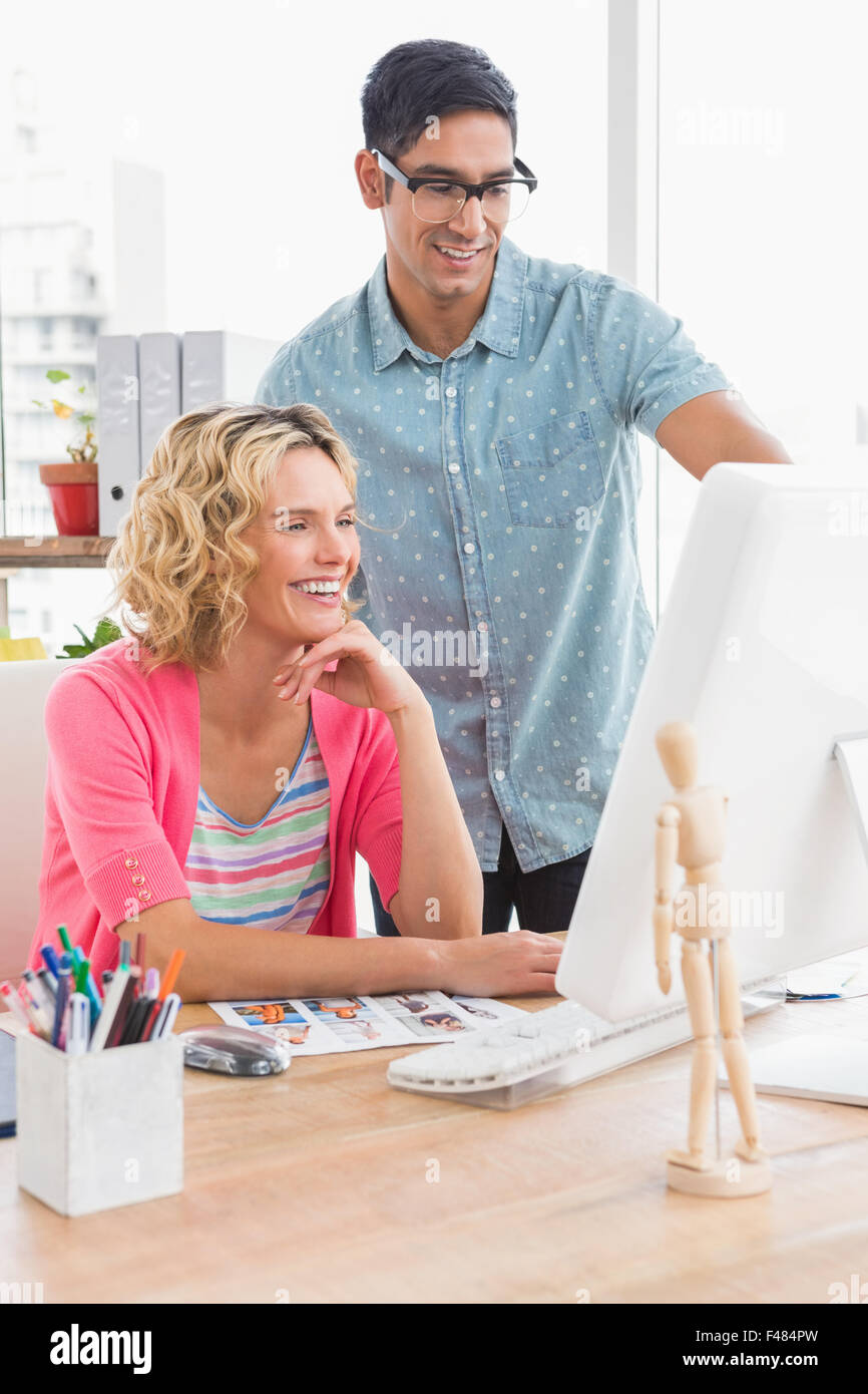 Smiling colleagues working on computer Stock Photo - Alamy