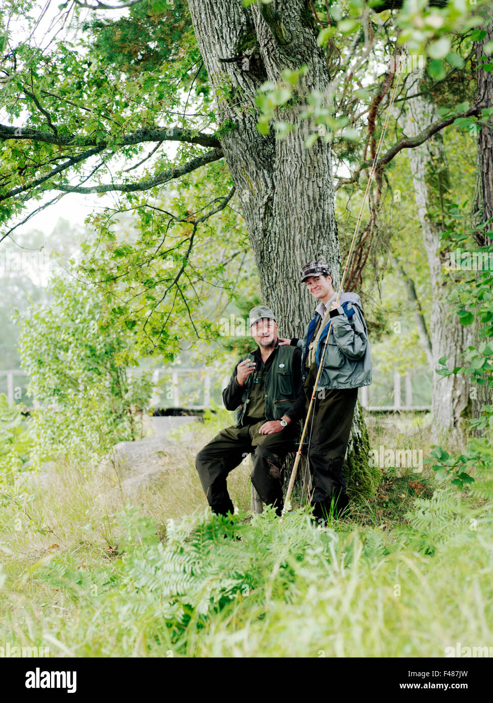 Anglers by a tree, Sweden Stock Photo - Alamy