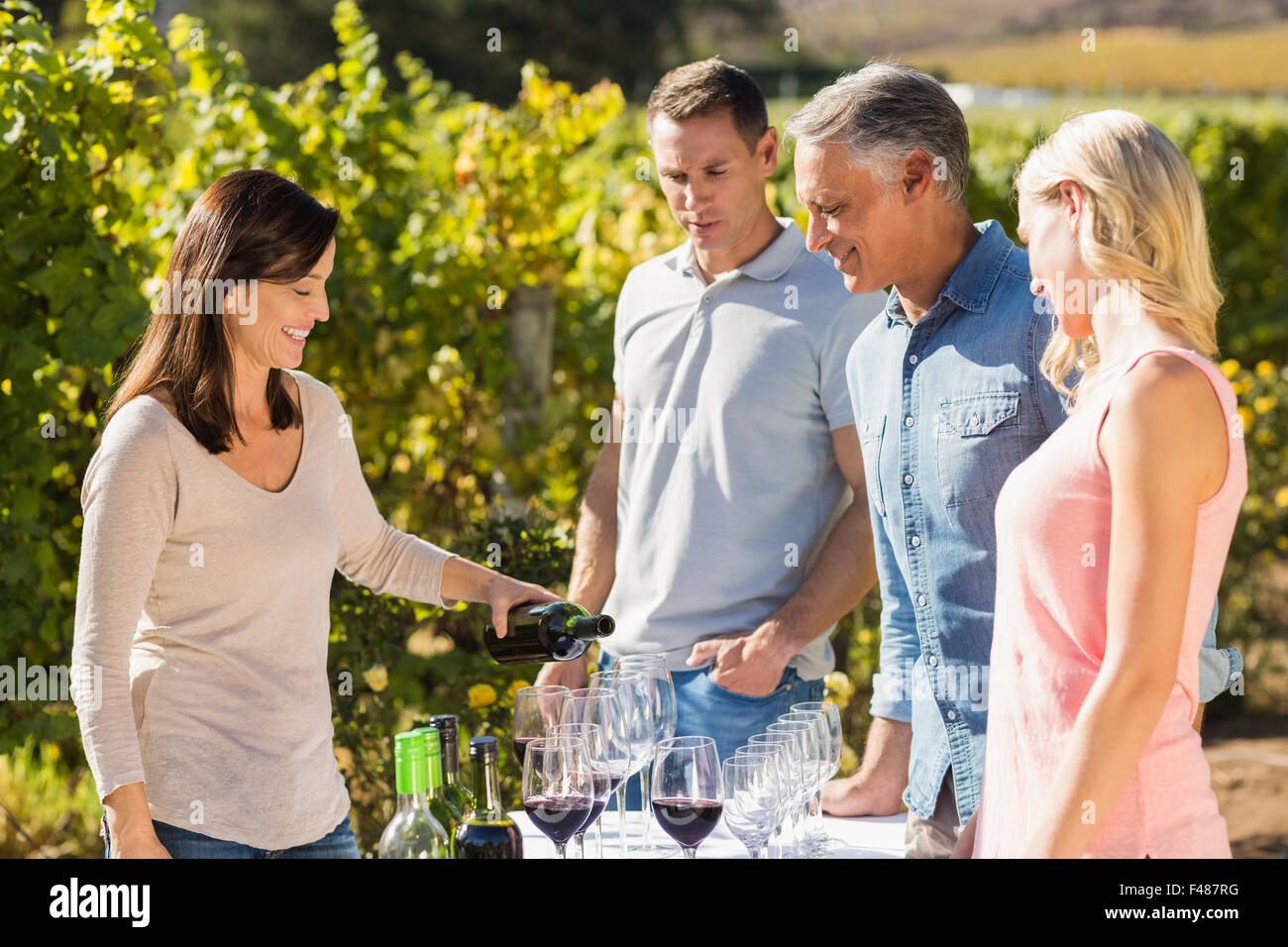 Smiling sommelier pouring wine in front of customers Stock Photo - Alamy