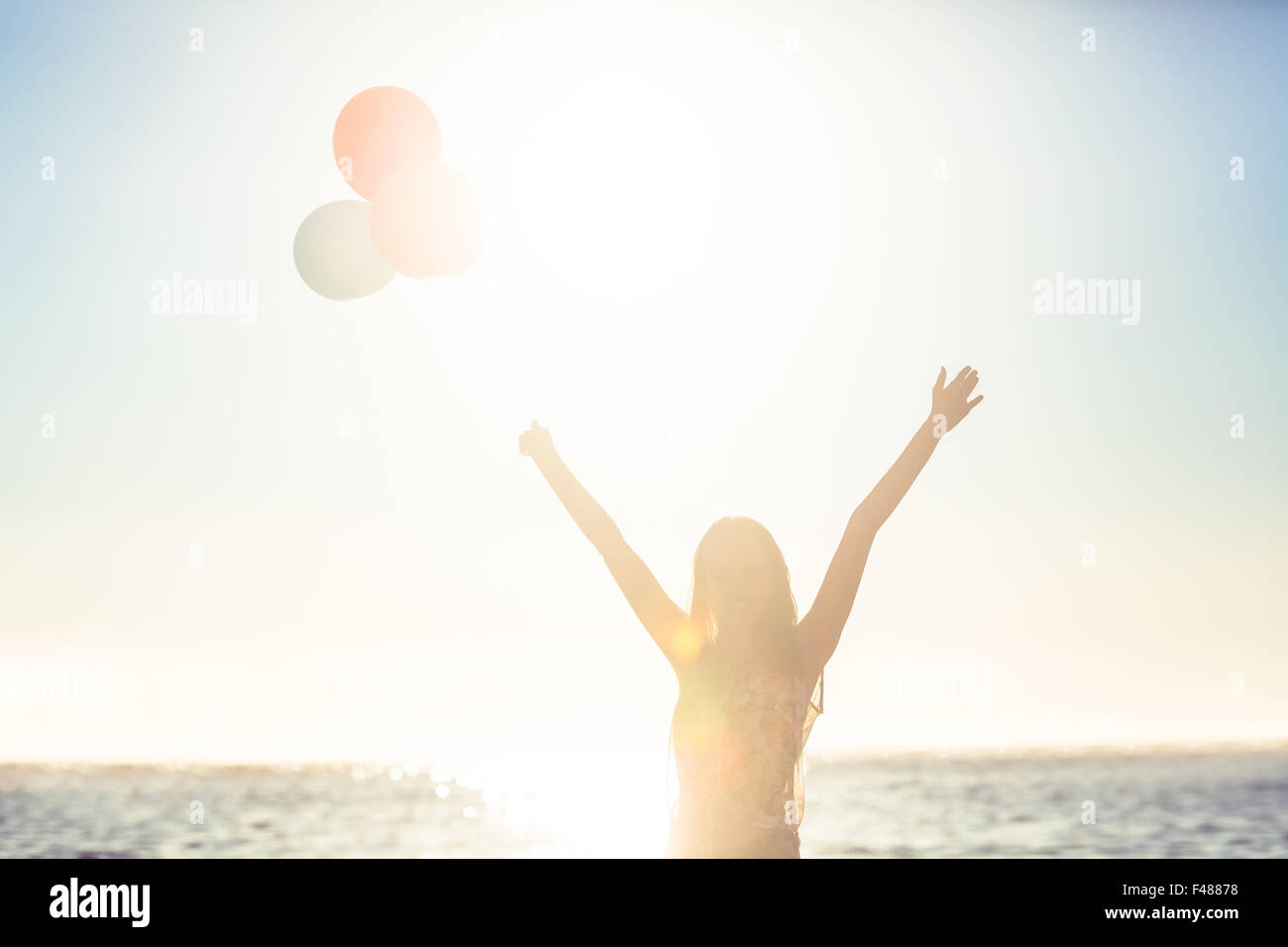 Happy girl playing on the sand with balloon Stock Photo - Alamy