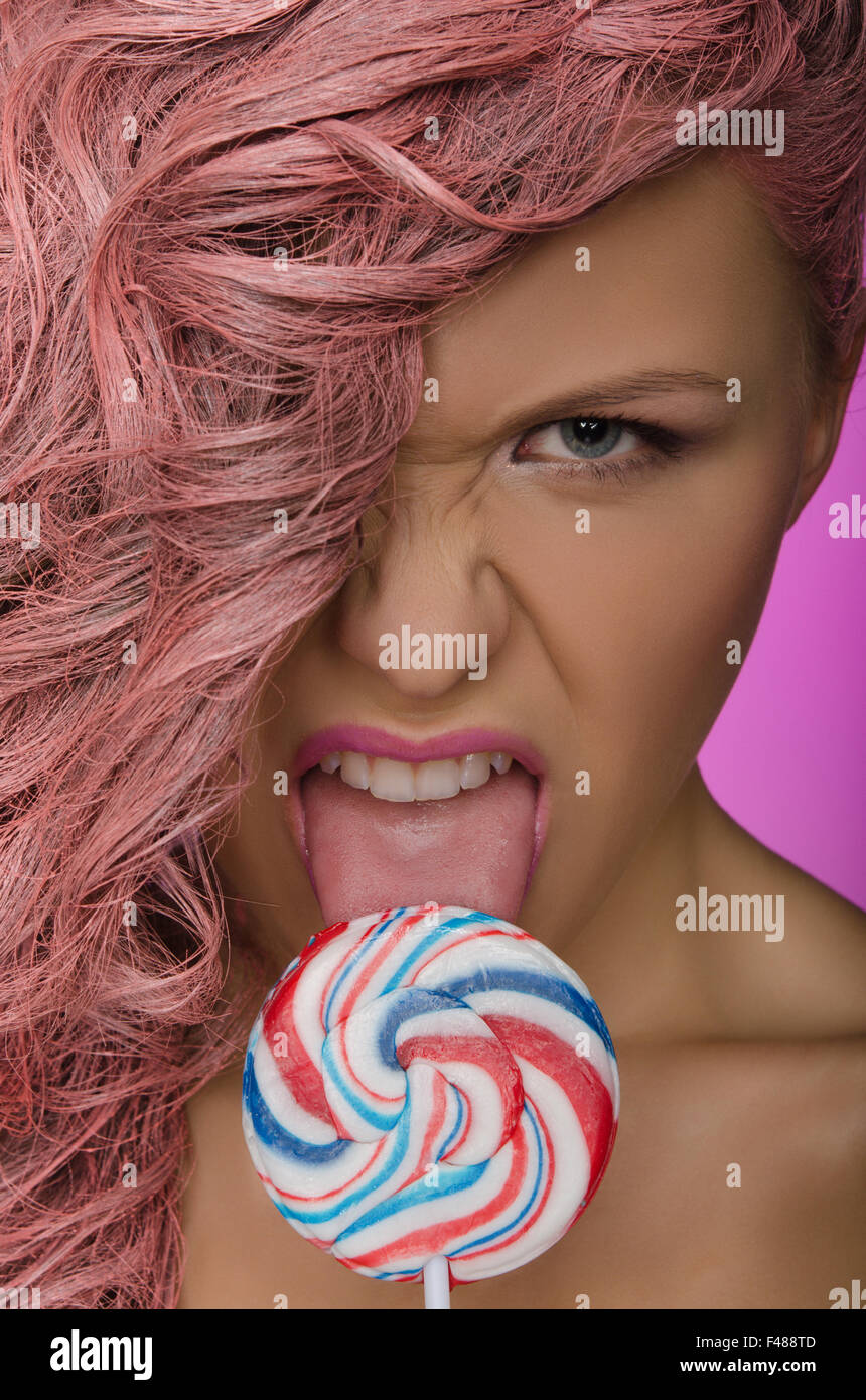 Angry woman with pink hair and candy Stock Photo - Alamy