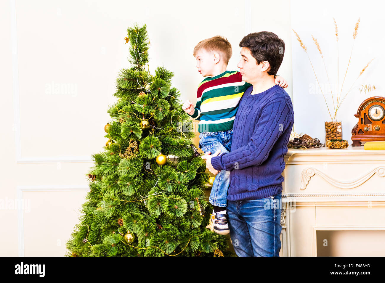 Son and dad decorating the christmas tree at home Stock Photo - Alamy