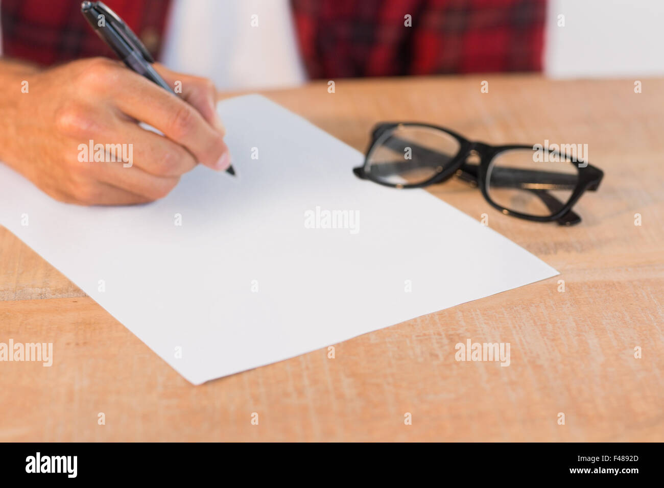 Right hand writing on white page on working desk Stock Photo - Alamy