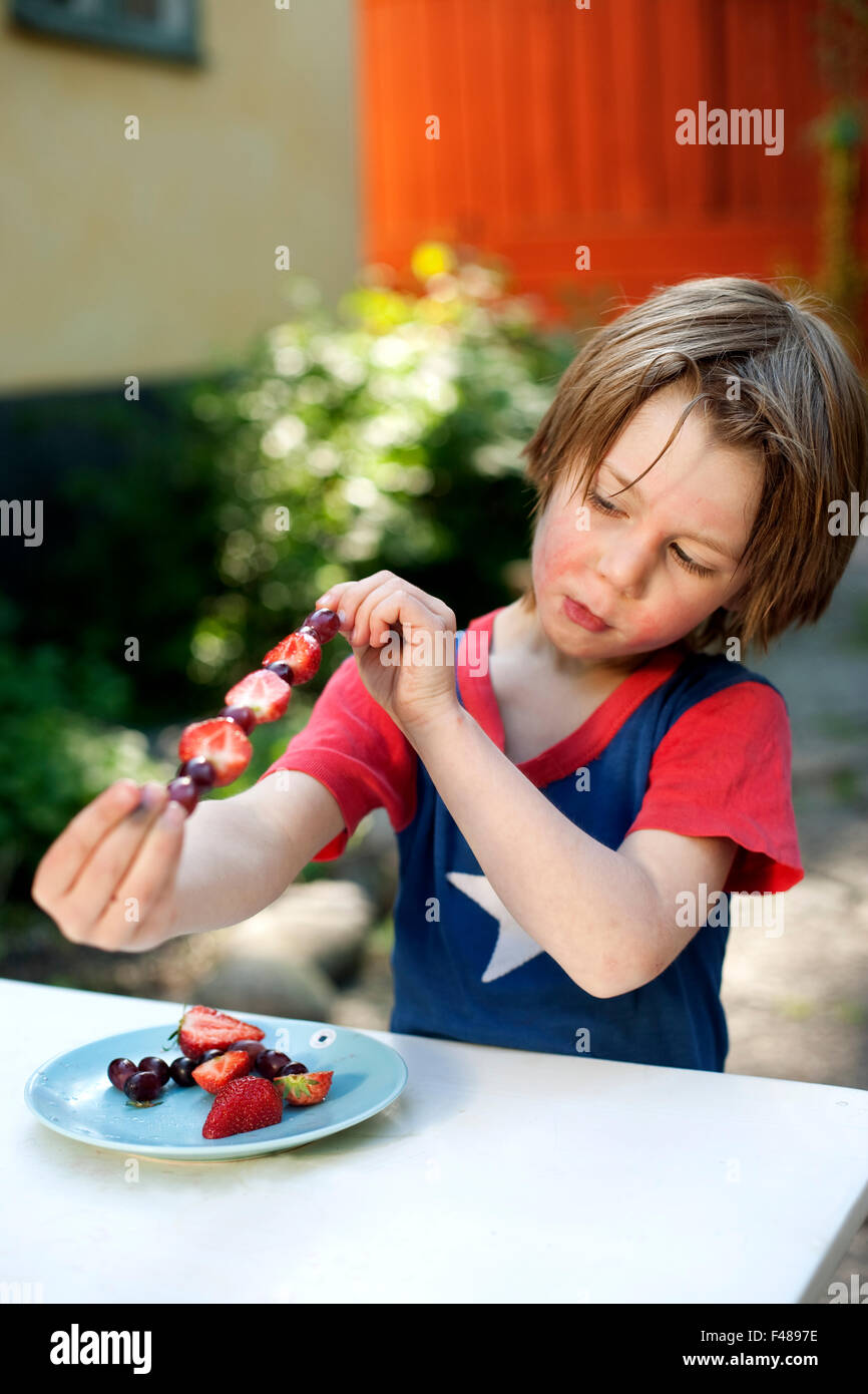 Boy eating berries on a skewer, Sweden Stock Photo - Alamy