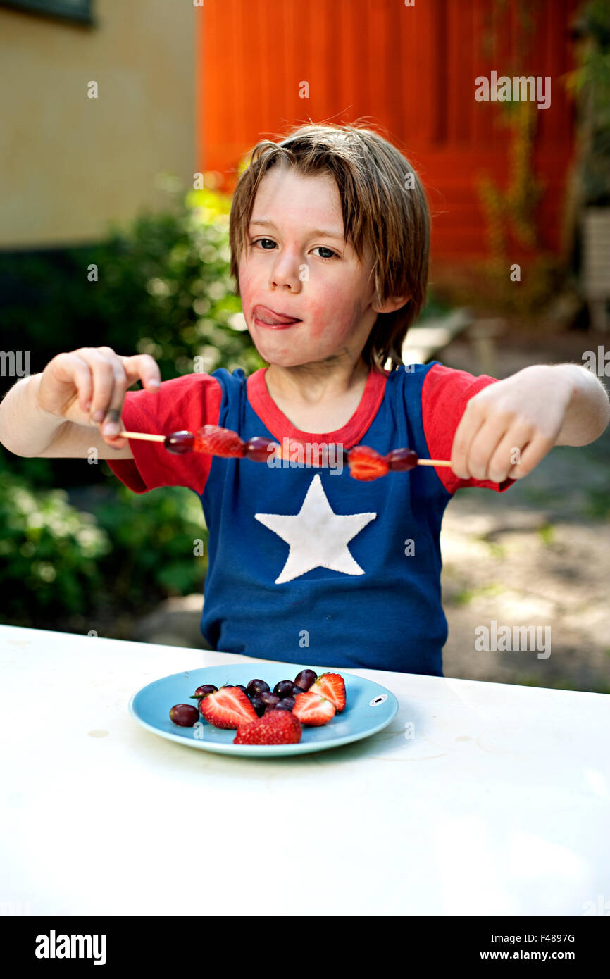 Boy eating berries on a skewer, Sweden Stock Photo - Alamy
