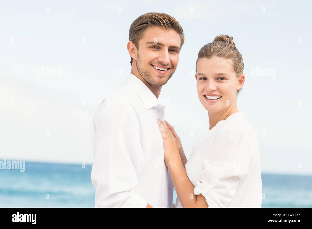Happy couple hugging and looking at camera Stock Photo - Alamy