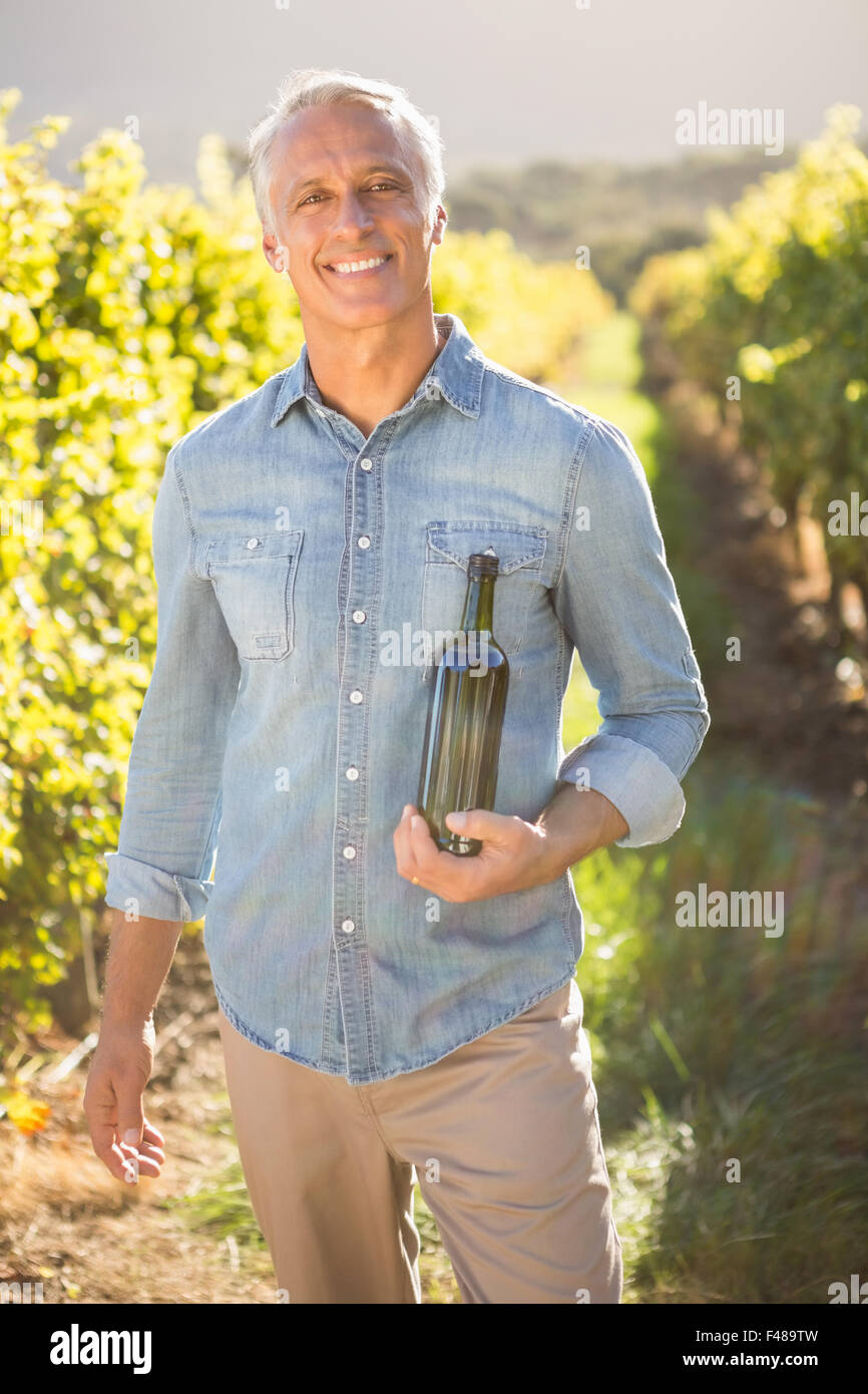Smiling vintner holding bottle of wine Stock Photo - Alamy