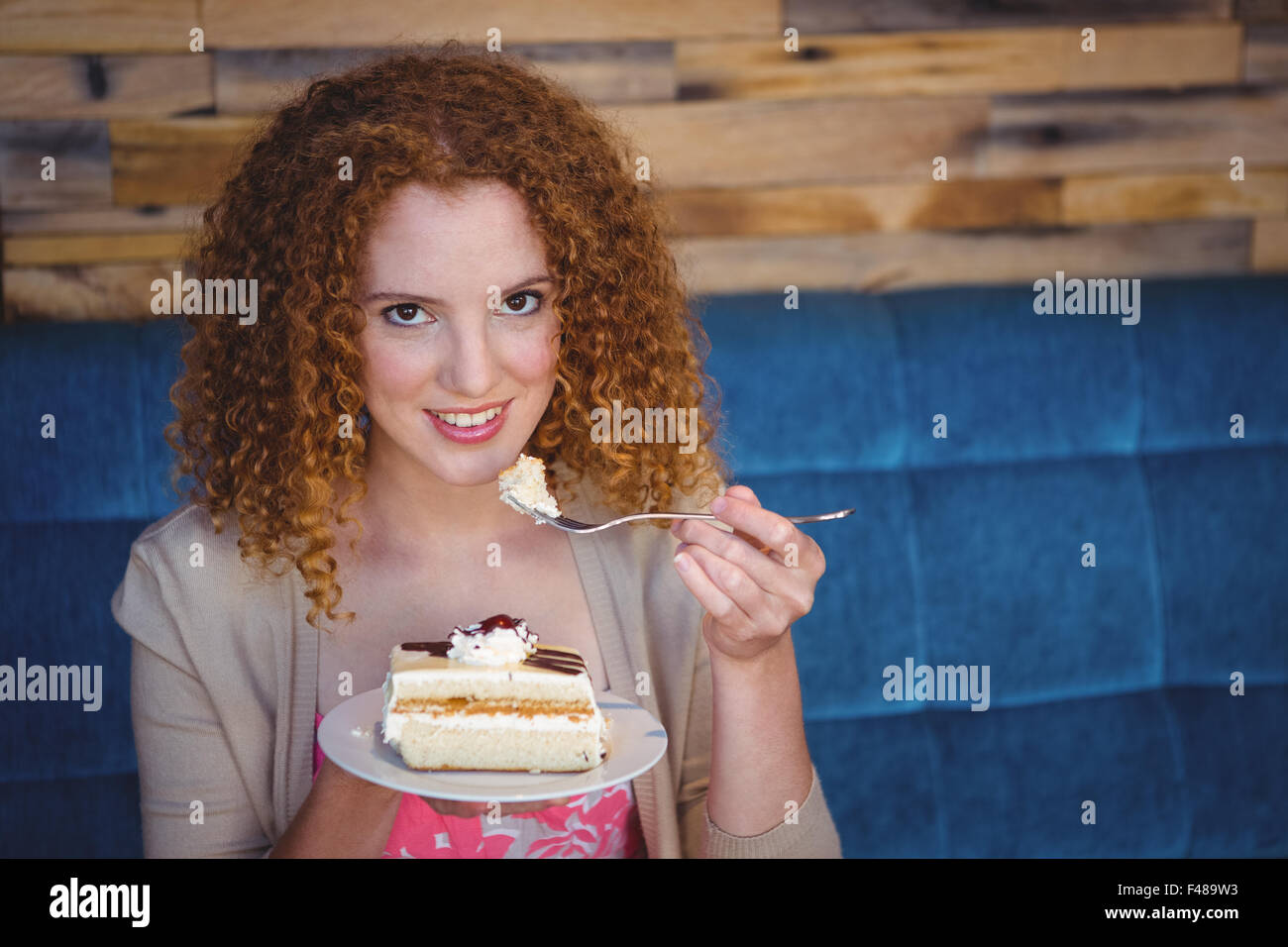 Portrait of a smiling pretty woman taking a piece of cake Stock Photo ...