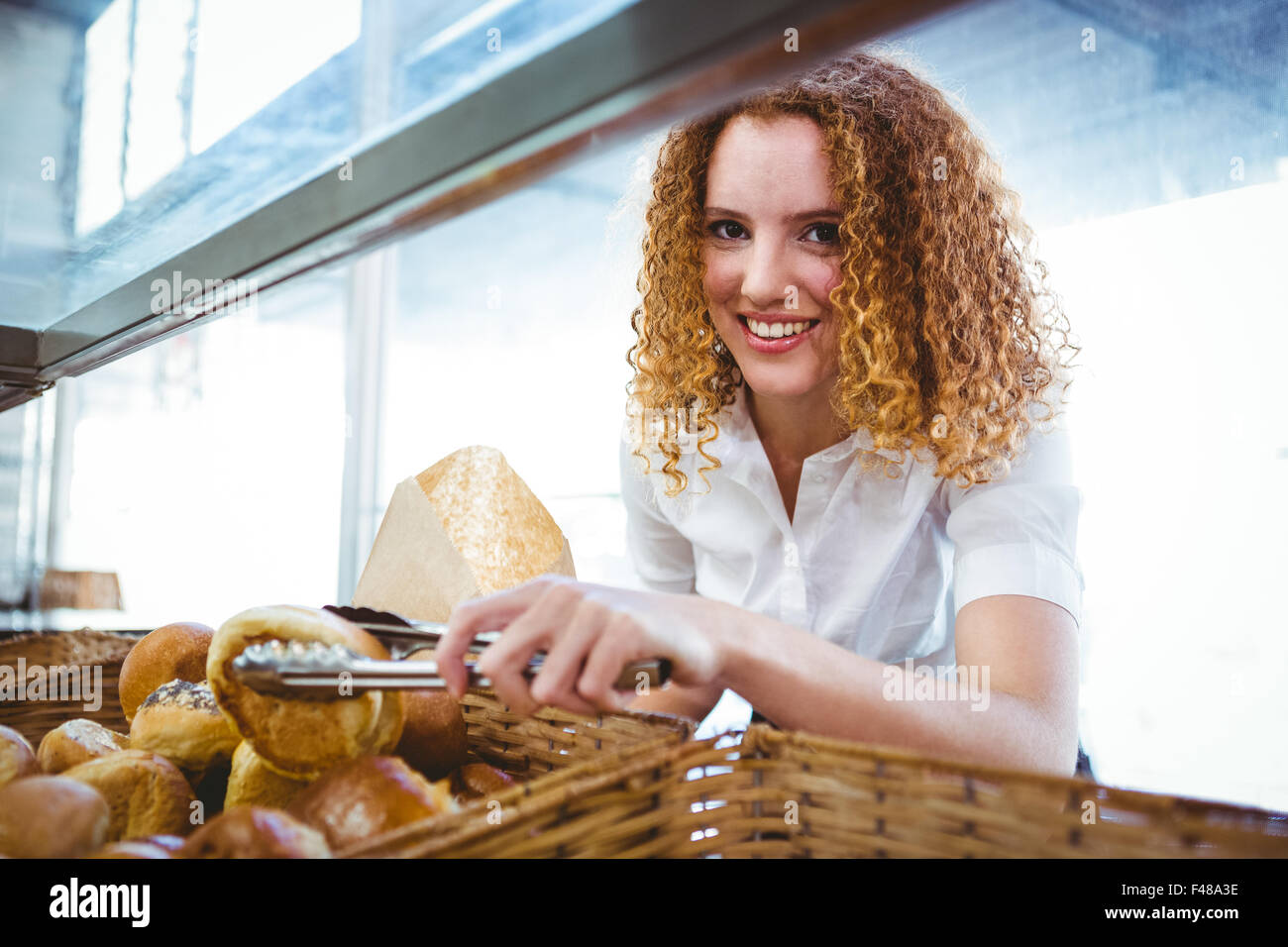 Barista putting pastry in paper bag Stock Photo - Alamy