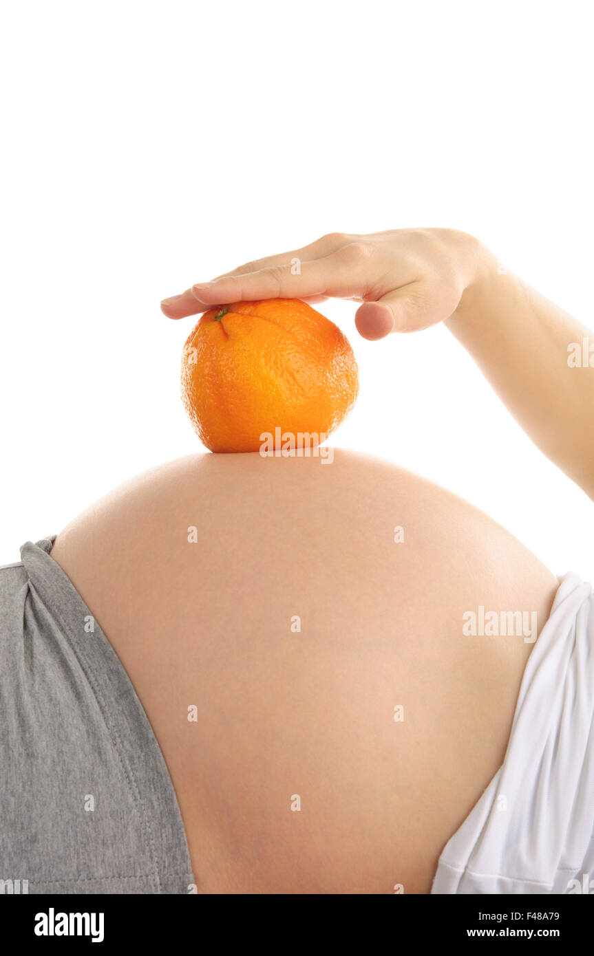 Pregnant woman's abdomen with orange Stock Photo - Alamy