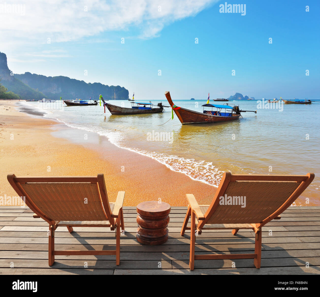 Two wooden chaise lounges and native boats Stock Photo - Alamy