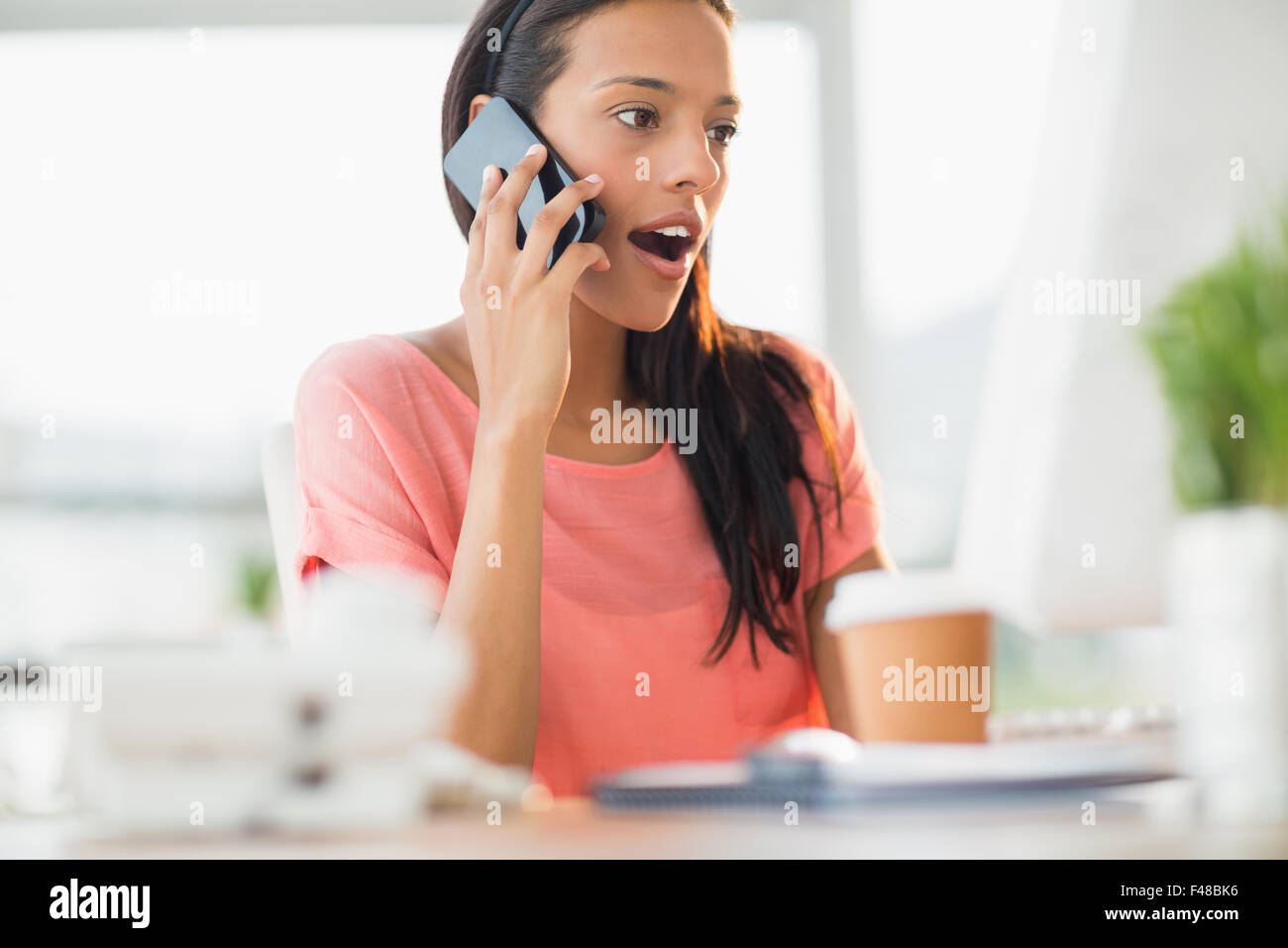 Surprised creative businesswoman having a phone call Stock Photo - Alamy