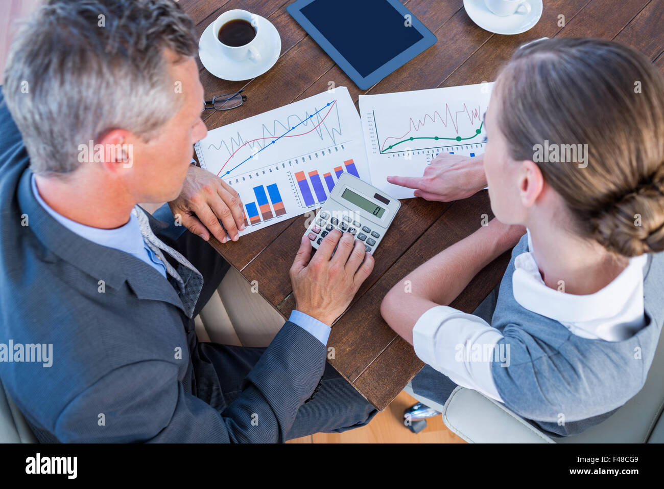 Serious business people using calculator Stock Photo - Alamy