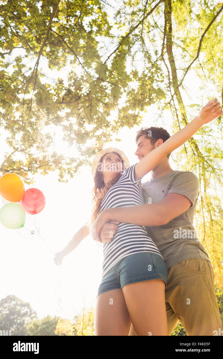 Cute couple hugging and holding balloons in the park Stock Photo - Alamy