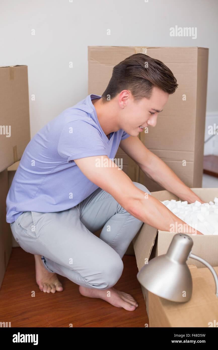 Happy handsome man unwrapping box Stock Photo - Alamy