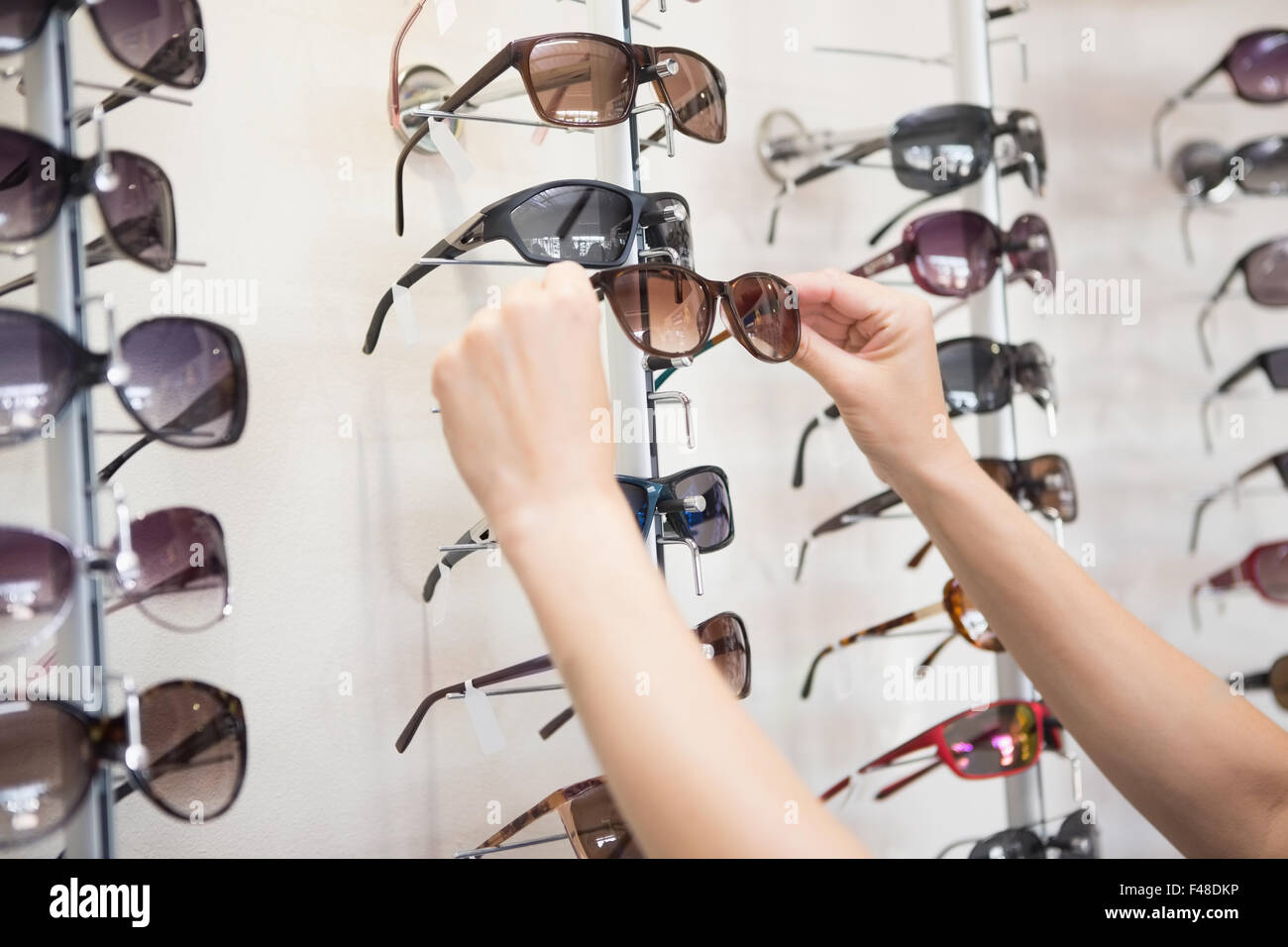 Woman taking sunglasses from the display Stock Photo - Alamy