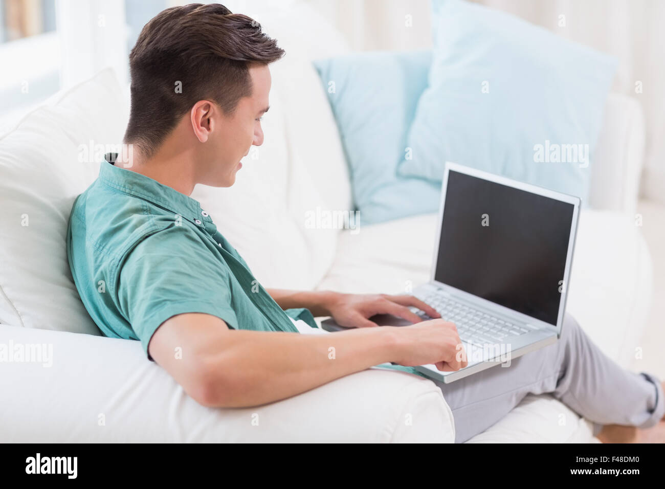 Smiling handsome man using a laptop Stock Photo - Alamy