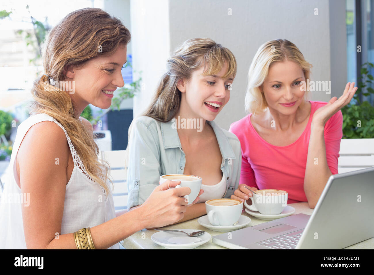 Beautiful women using laptop and smiling Stock Photo - Alamy
