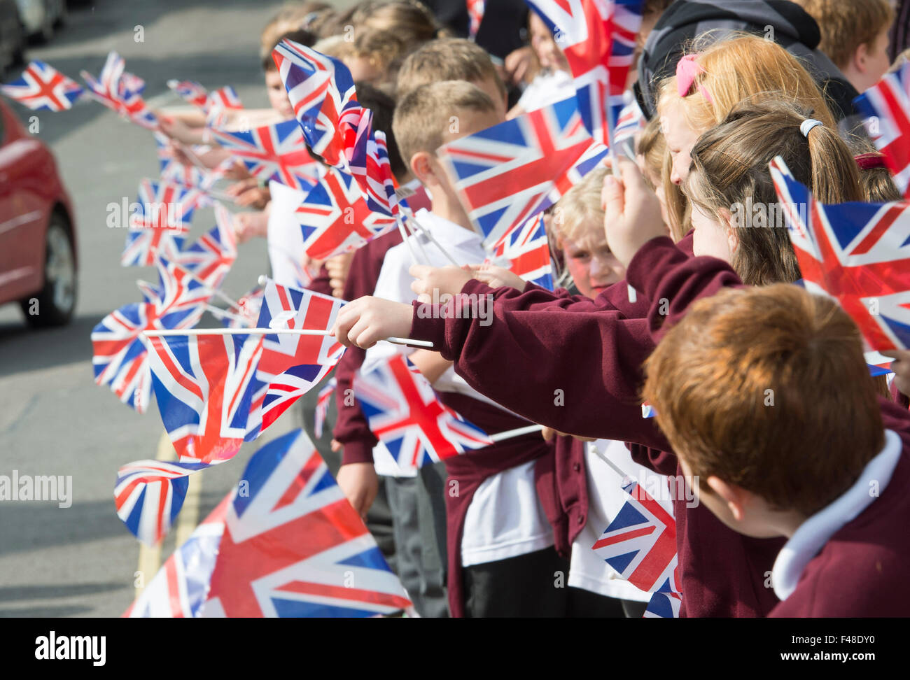 School children wave union flags as the Tour of Britain passes through ...