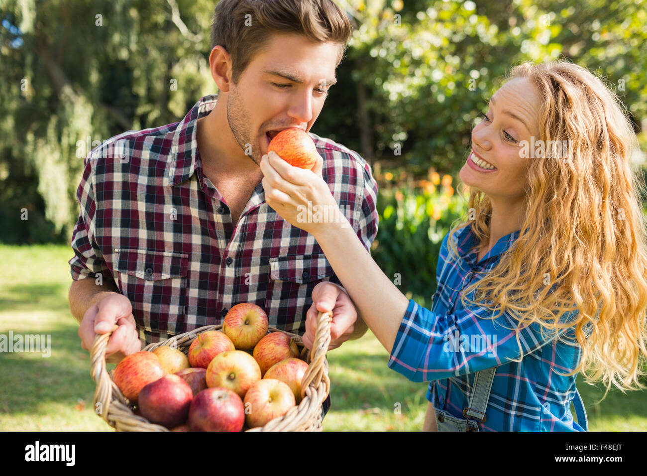 Happy woman giving apple to her husband Stock Photo - Alamy