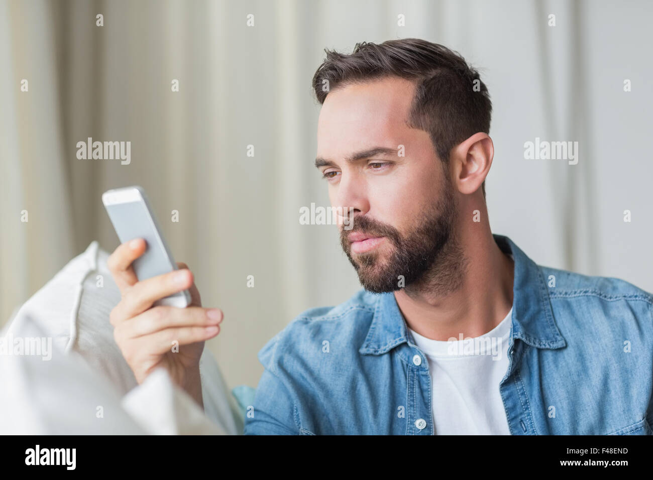 Thoughtful man sending a text message Stock Photo - Alamy
