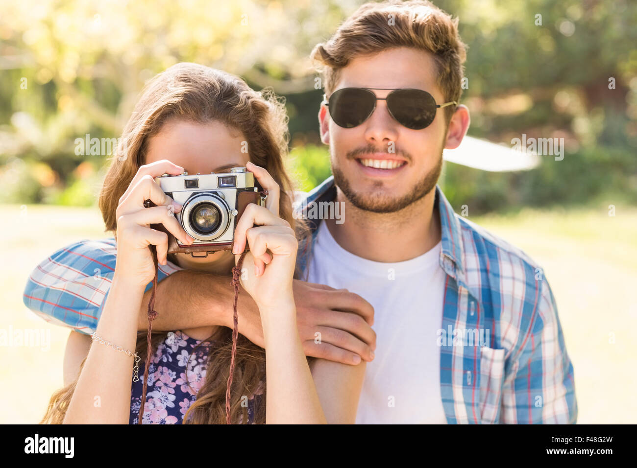 Cute couple taking pictures with retro camera Stock Photo - Alamy