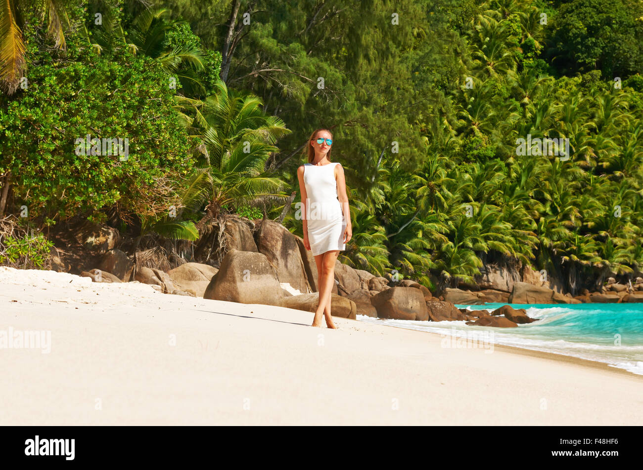 Woman wearing dress on beach at Seychelles Stock Photo - Alamy