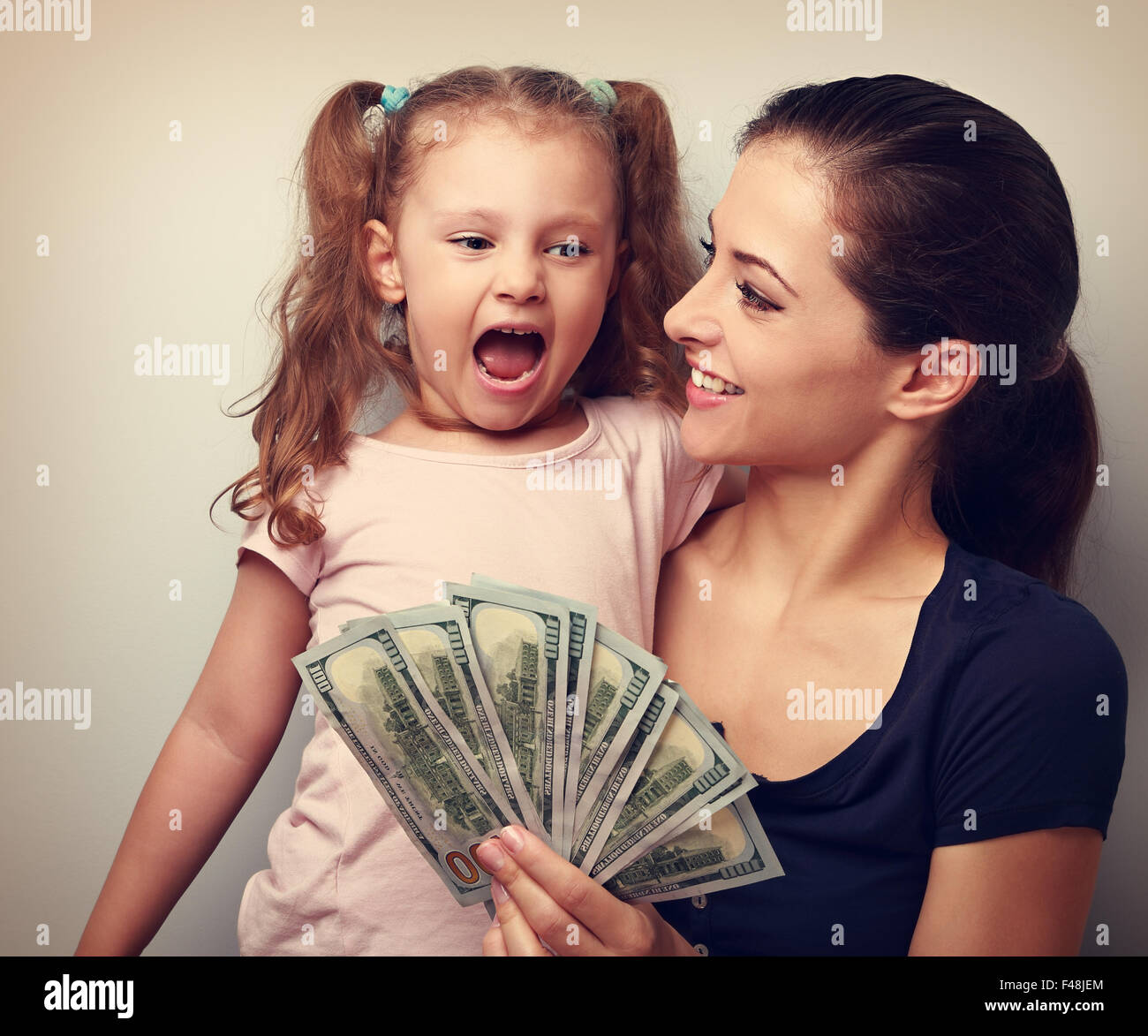 Happy smiling family holding dollars and thinking how to spend the ...