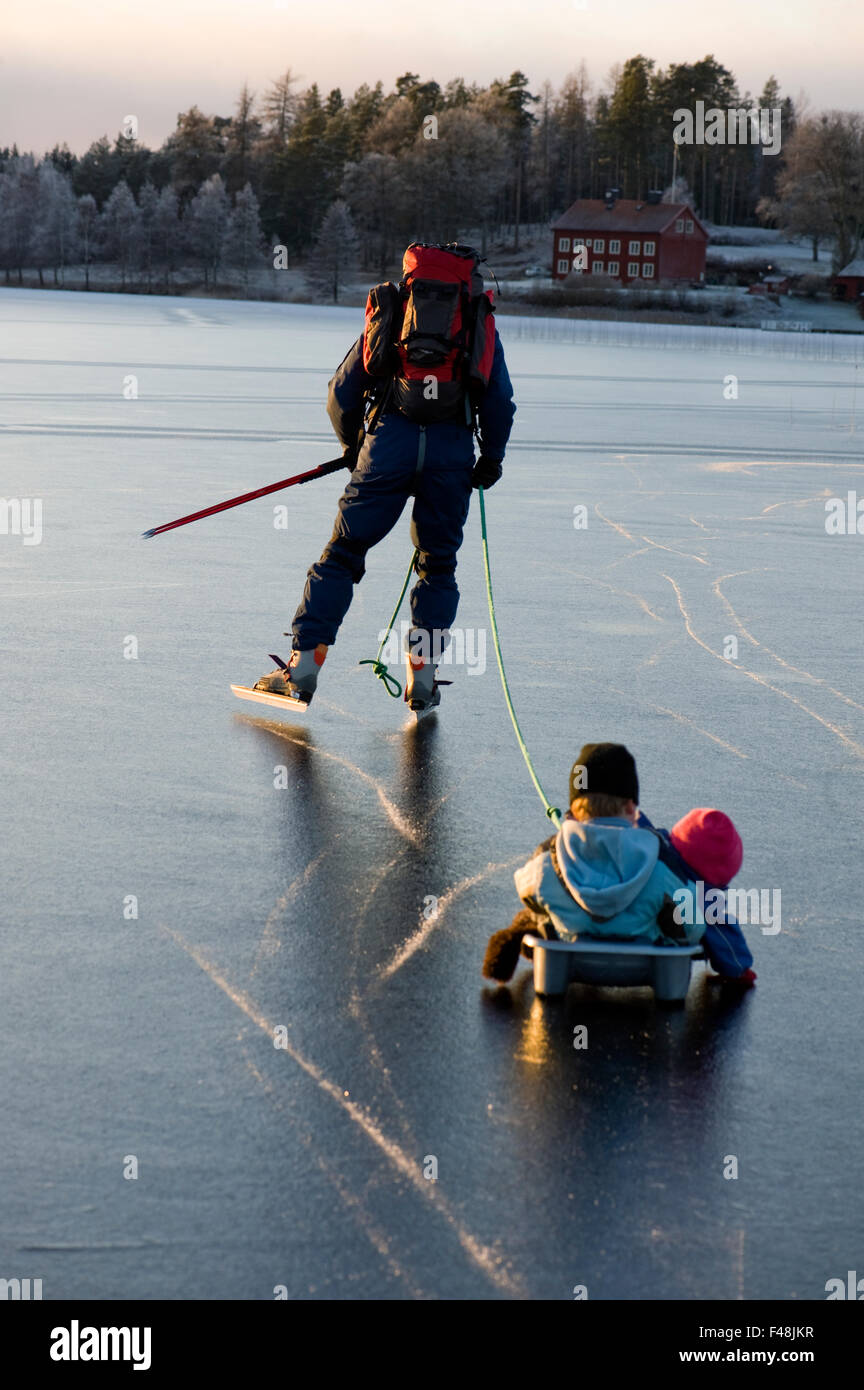 Man skating with children in a little sledge, Sweden Stock Photo - Alamy