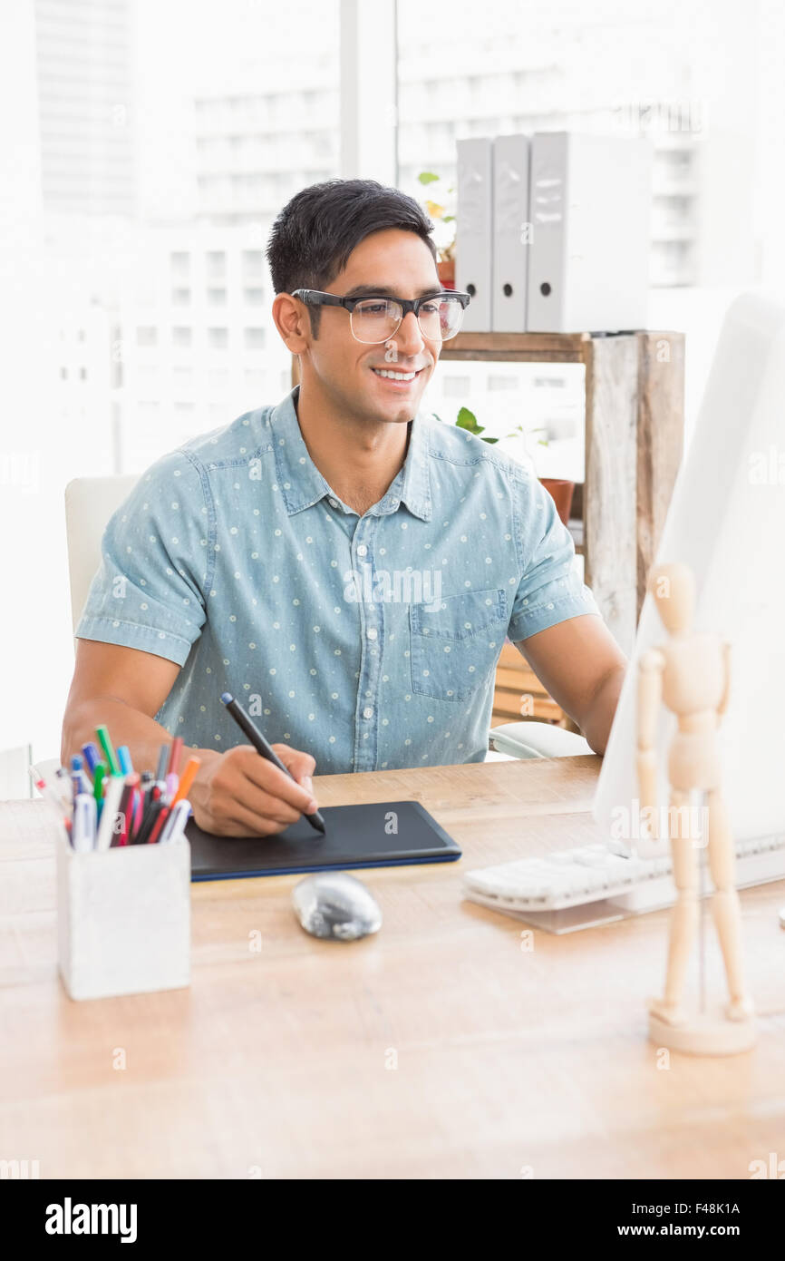Smiling casual businessman using computer and digitizer Stock Photo - Alamy