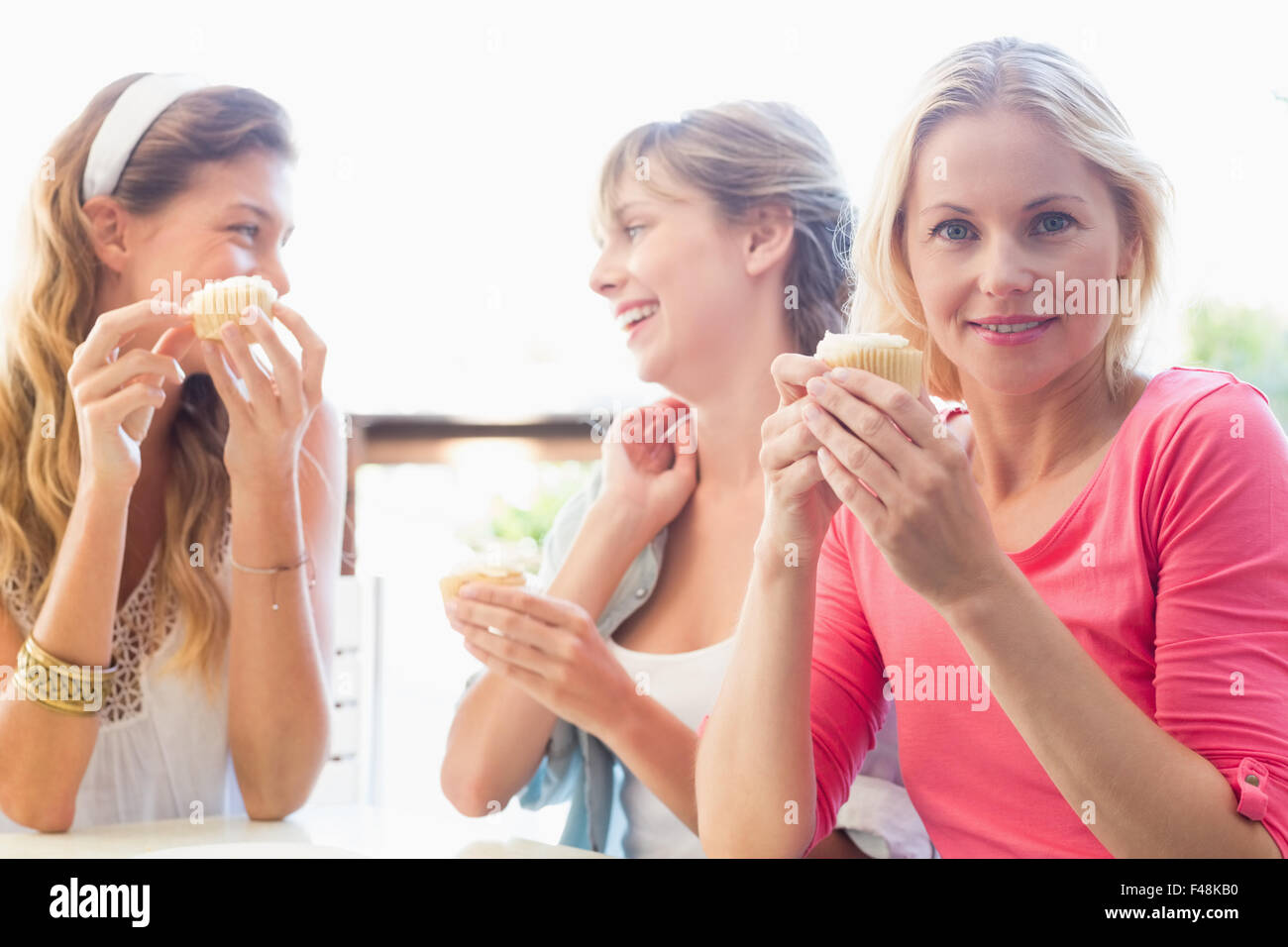 Beautiful women smiling and eating cake Stock Photo - Alamy