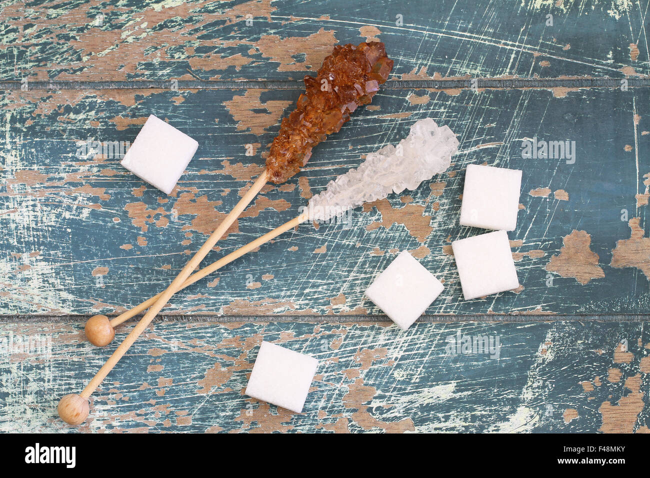 White sugar cubes and white and brown sugar sticks on rustic wooden ...
