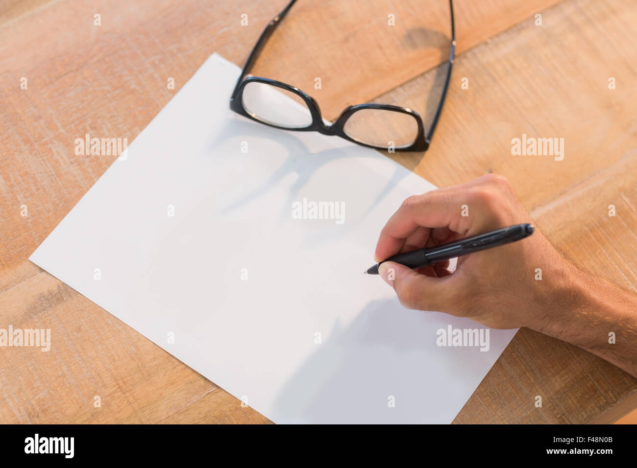 Right hand writing on white page on working desk Stock Photo - Alamy