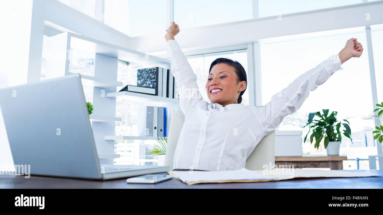 Businesswoman cheering behind laptop computer Stock Photo - Alamy