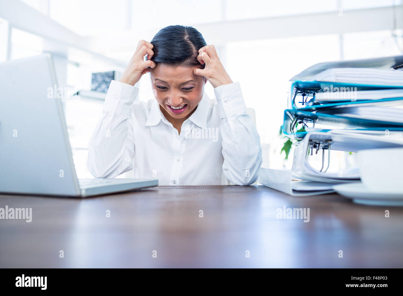Businesswoman getting stressed at her desk Stock Photo - Alamy
