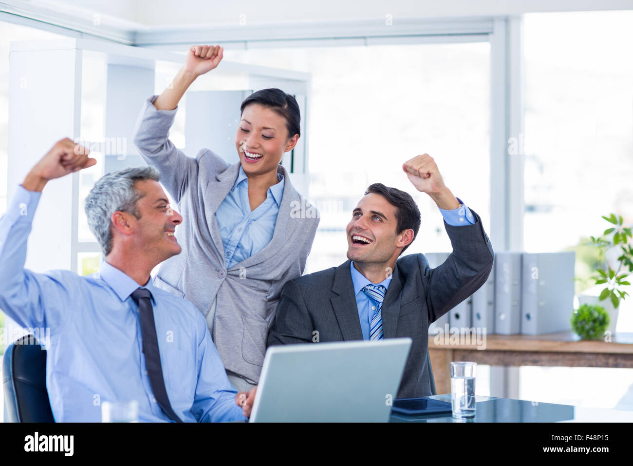 Happy business people cheering together Stock Photo - Alamy