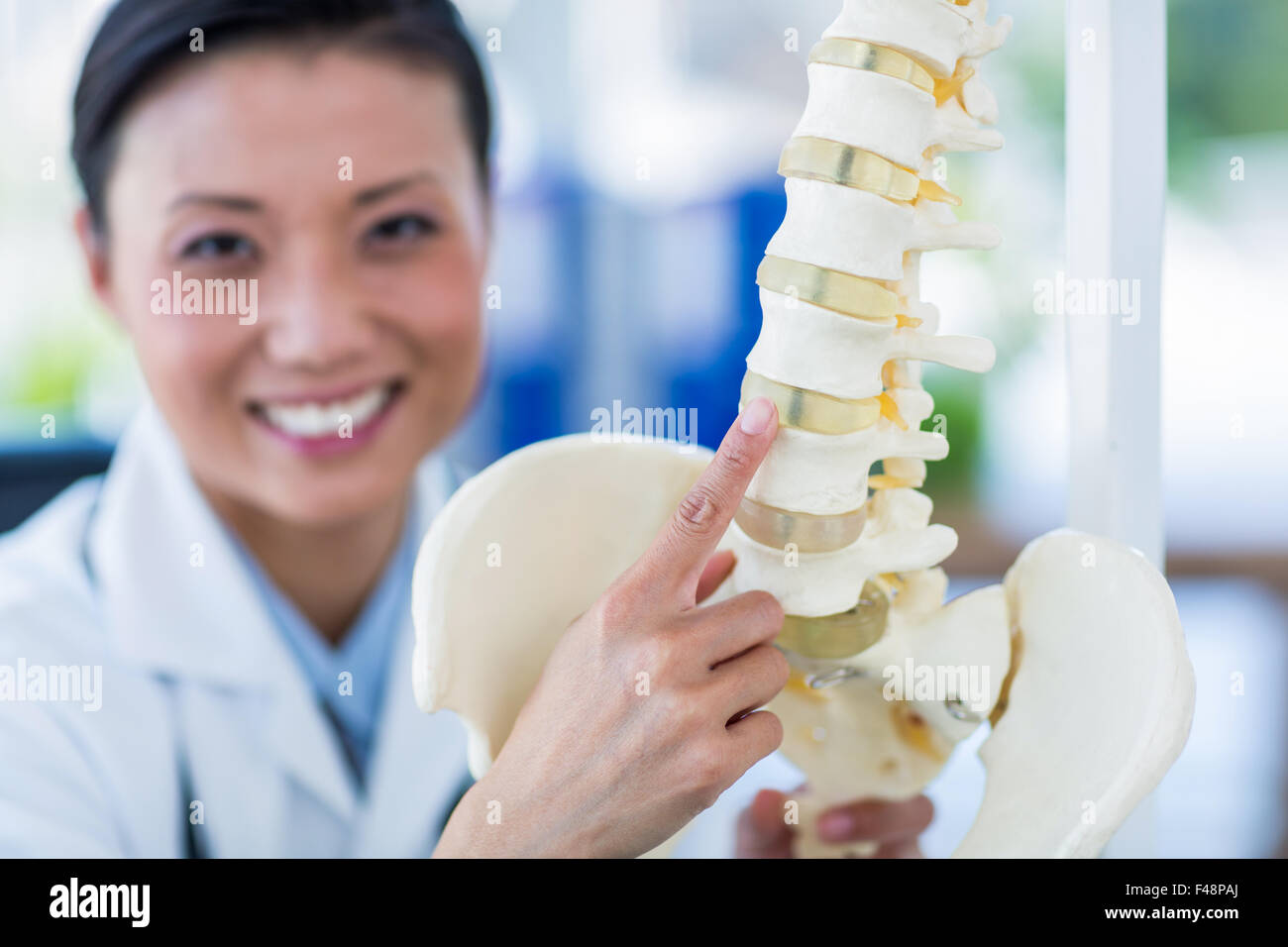 Smiling doctor showing anatomical spine Stock Photo - Alamy