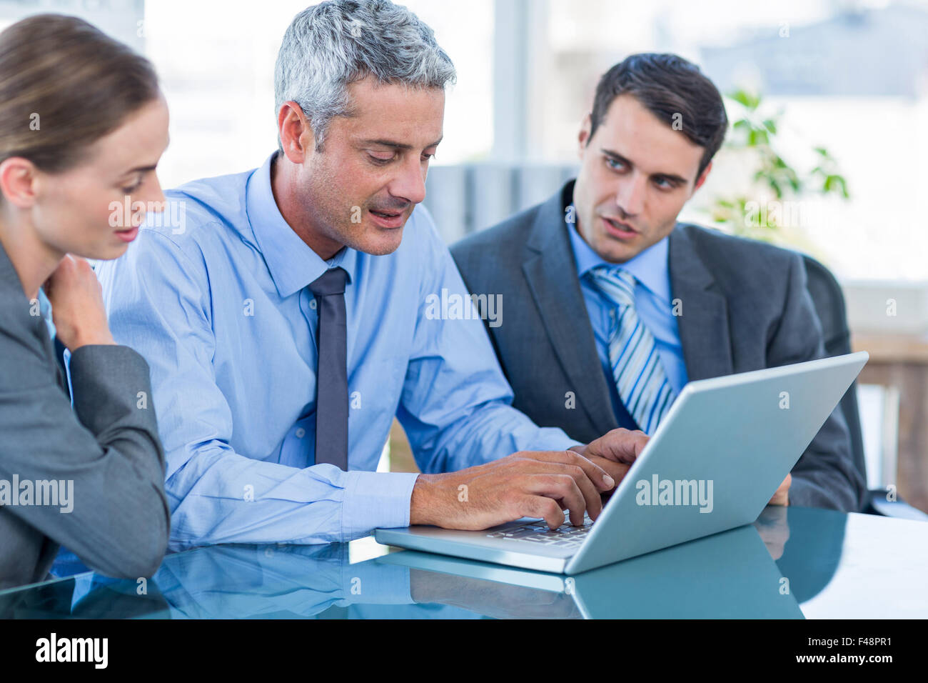 Business people looking at laptop computer Stock Photo - Alamy